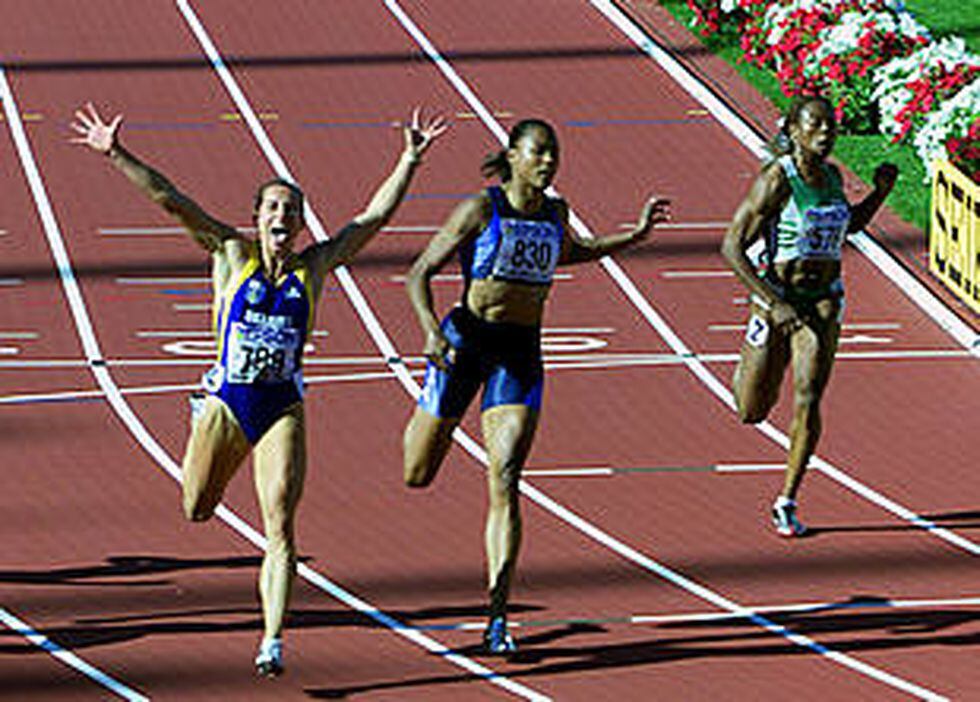 Zhanna Pintusevich levanta los brazos al cruzar la línea de meta por ...